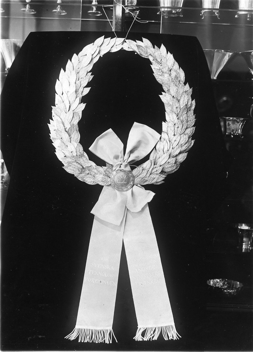 Lagerkrans av vit metall med logo för Svenska Teknologföreningen samt ...