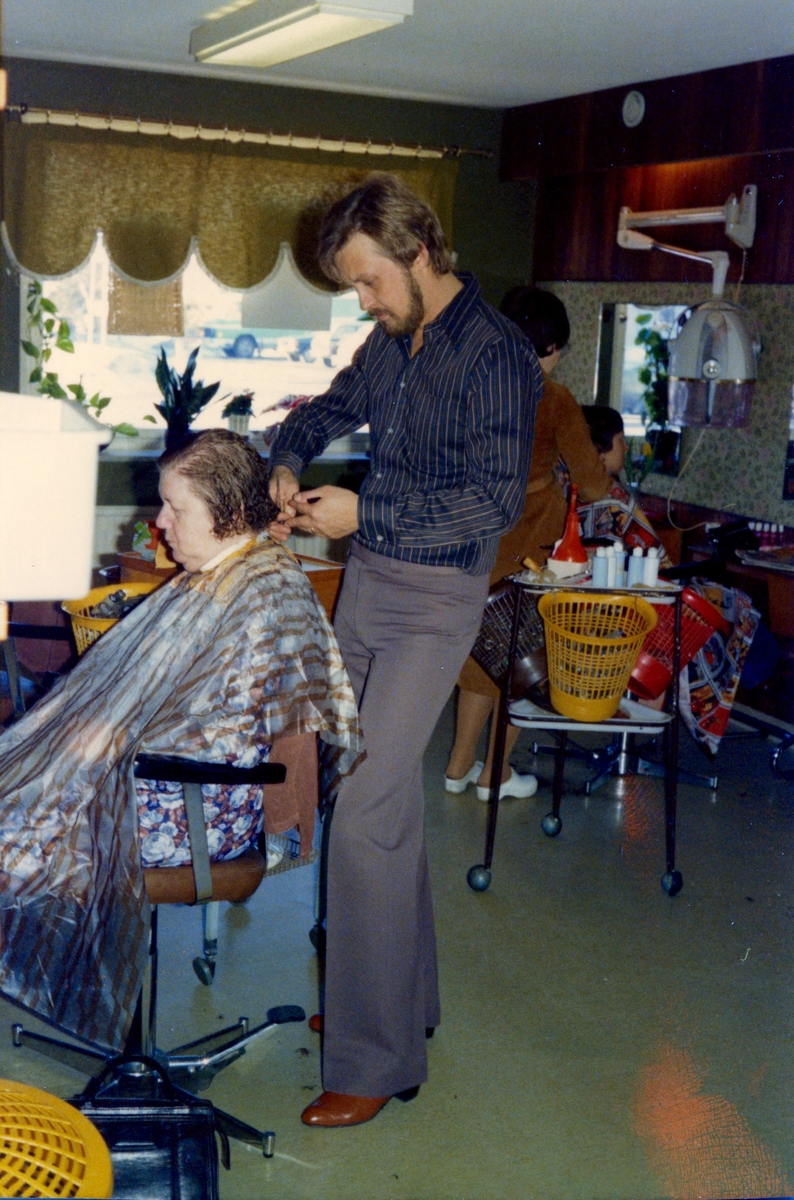 Frisören och ägaren Leif Westerberg klipper en kund (okänd kvinna) som ...