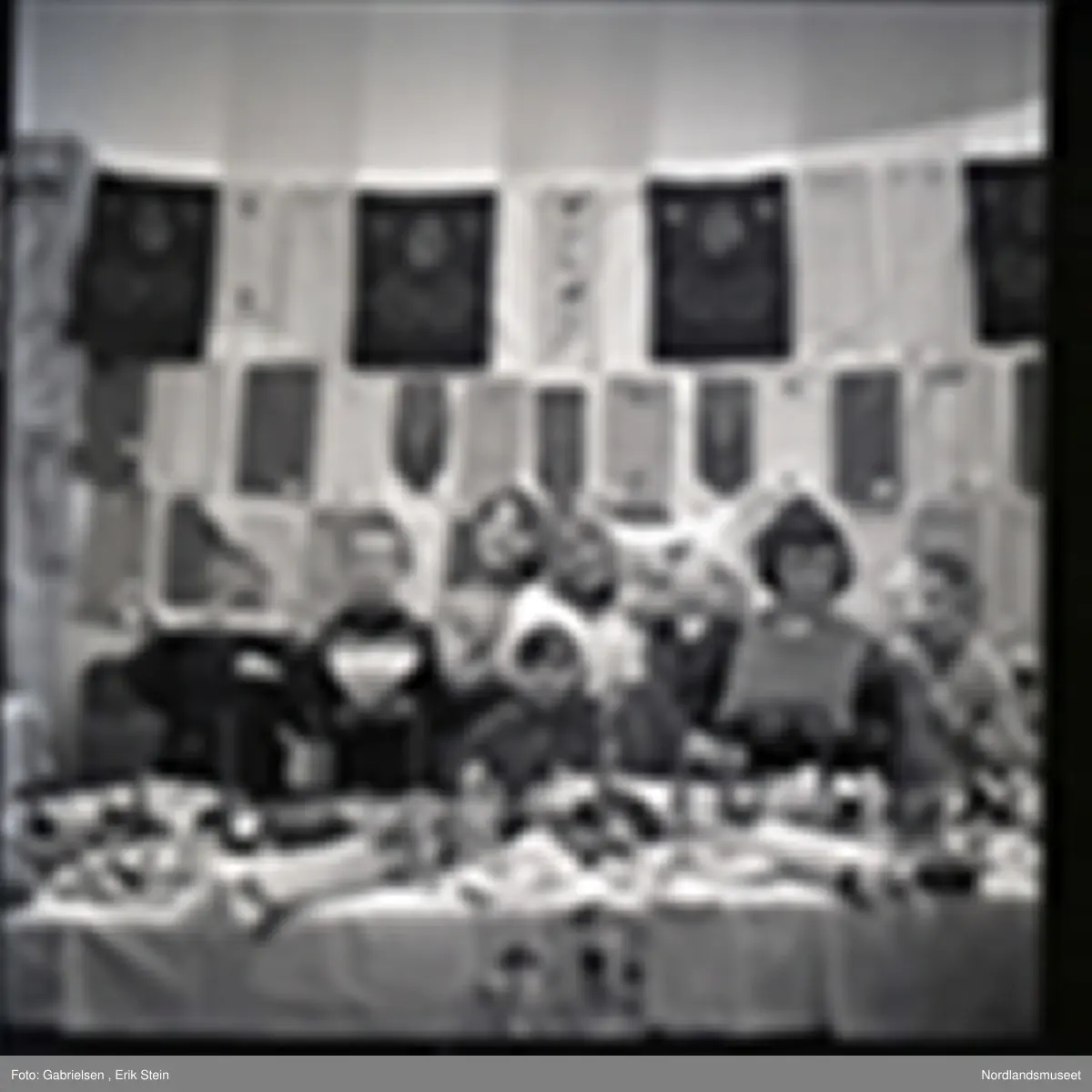 Fotografi av en gruppe med barn som selger julepynt og andre ting inne ...