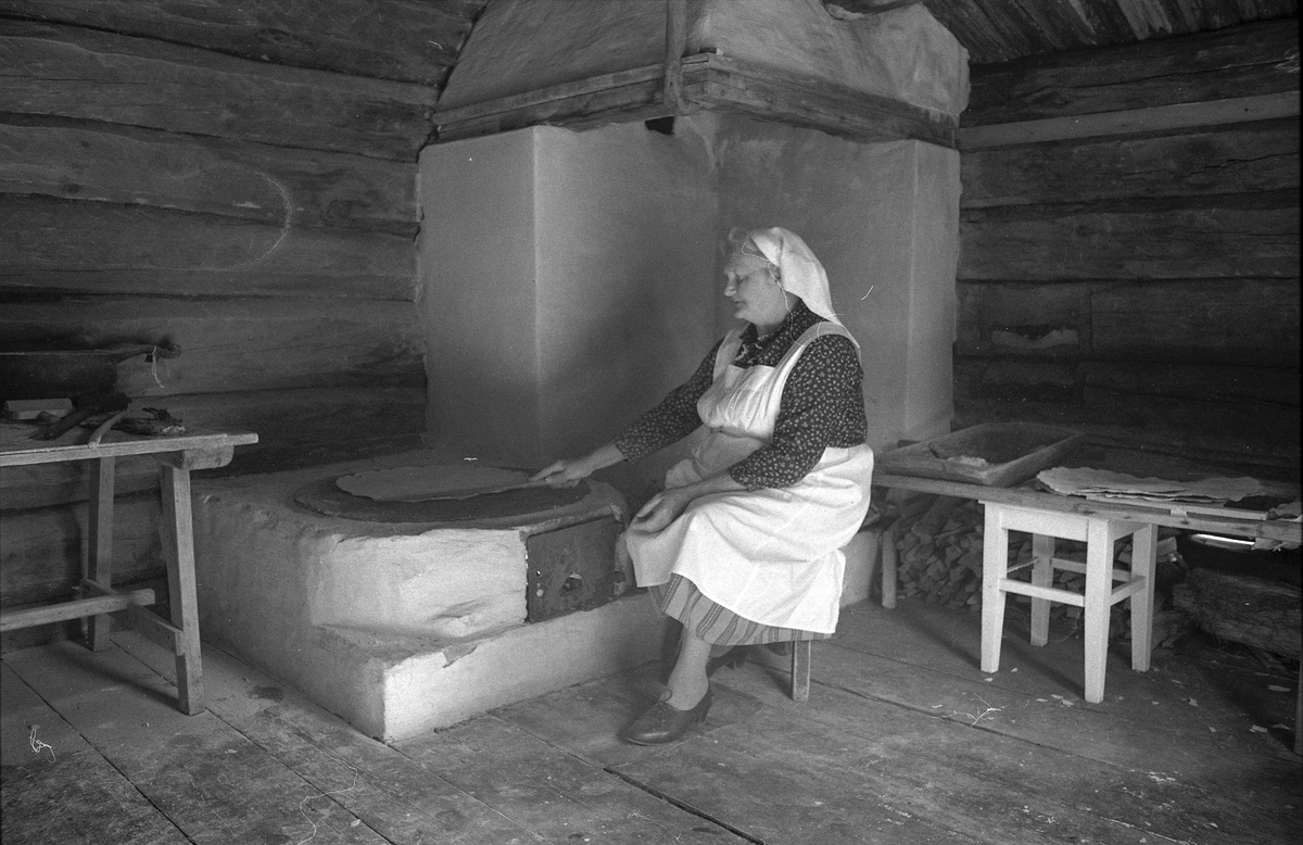 Liv i stuene 1975. Flatbrødbaking i Eldhuset, Tynsettunet. (Foto: A. Eckhoff). - Anno ...