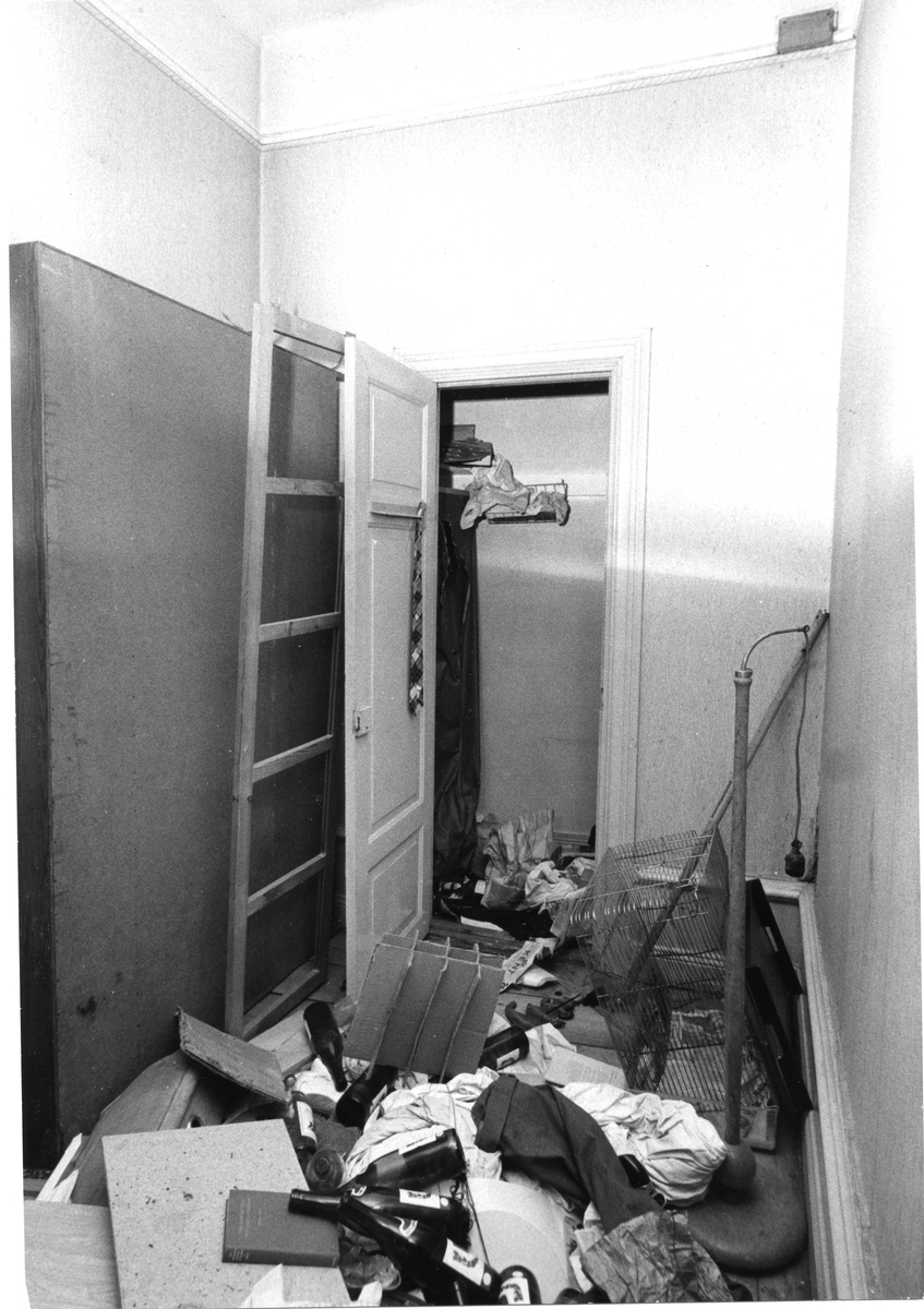 Litet rum med garderob. Golvet fyllt med bråte bl a en del urdruckna ...