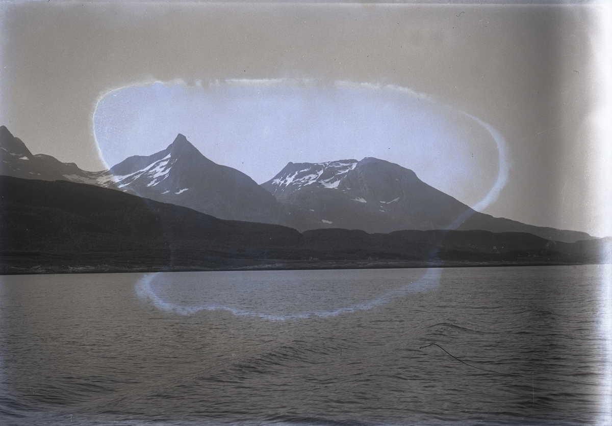 Hytte og fjellene gak sett fra båt. Bildet var i boksen SVB 3003 ...