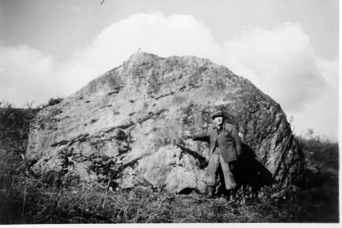 Arthur Tennvassås står ved en stor stein som blir kalt for Bjørnsteinen ...