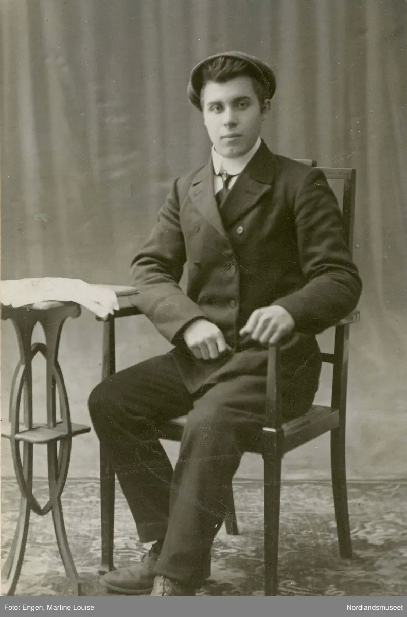 Portrett av ung mann som sitter på en stol. Han har en sixpence på ...