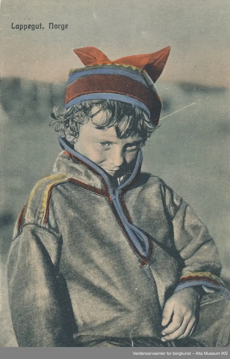 Portrett av en samisk gutt. Han er ikledd kofte og lue ...