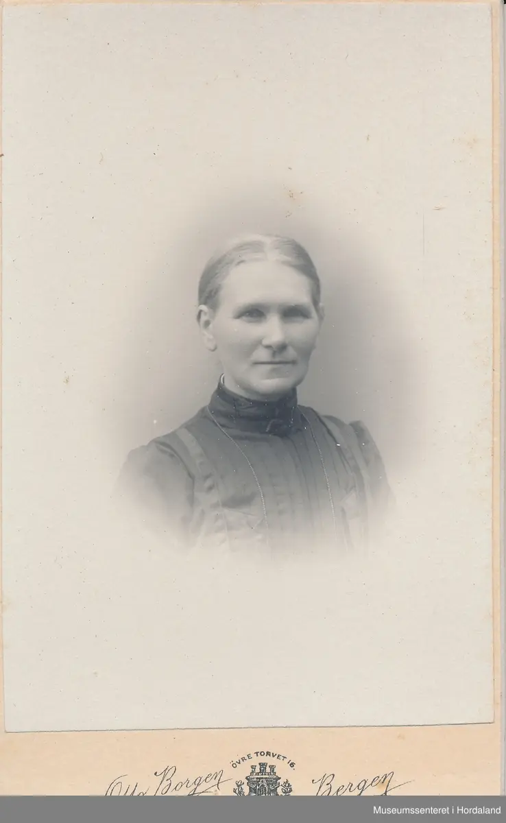 portrettfotografi av kvinne med blondt hår med midtskill og knute i ...